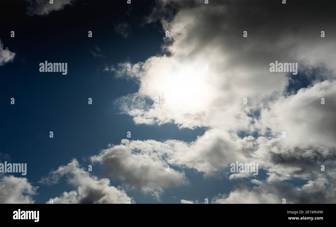 Cloudy blue sky with sun Stock Photo - Alamy
