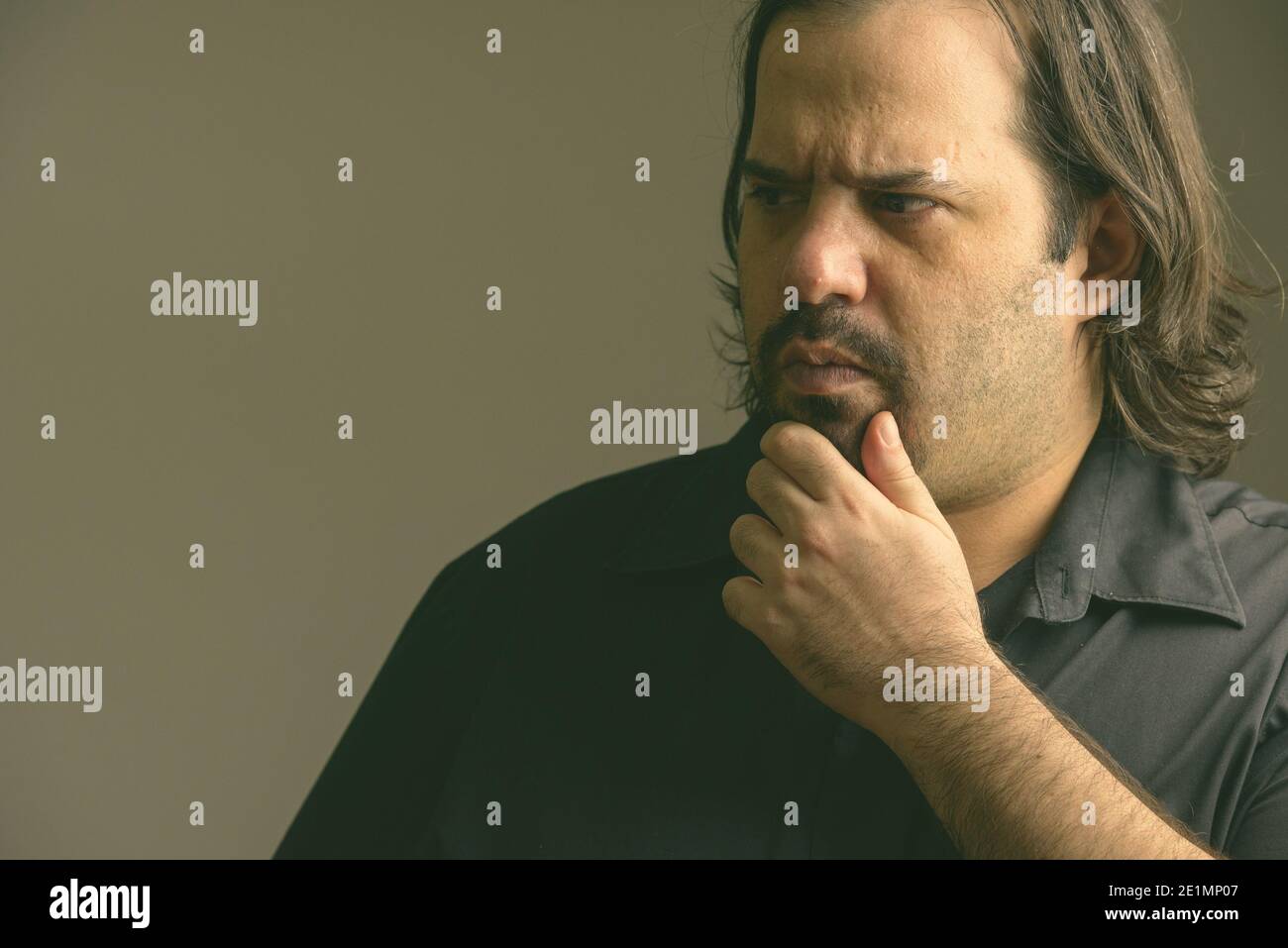 Close up of fat Caucasian man thinking in the dark in black and white ...