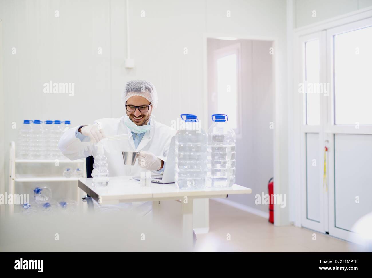 Young professional employee in food factory working on some experiments ...