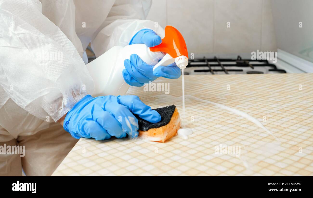 Closeup of desinfecting kitchen tabletop with chemical detergent ...