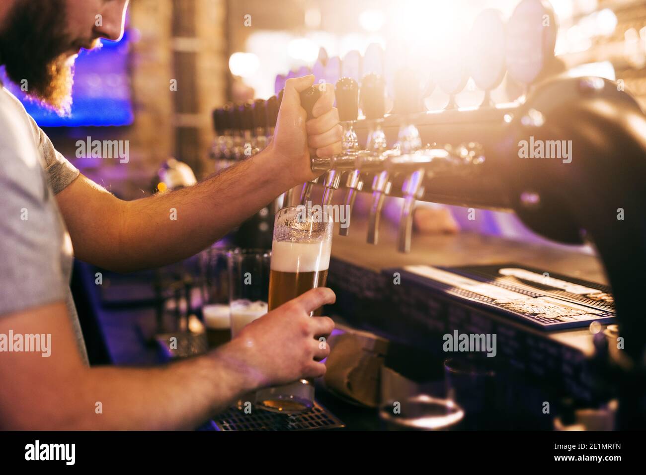 Close up of bartender pouring beer into glass. Pub interior Stock Photo - Alamy