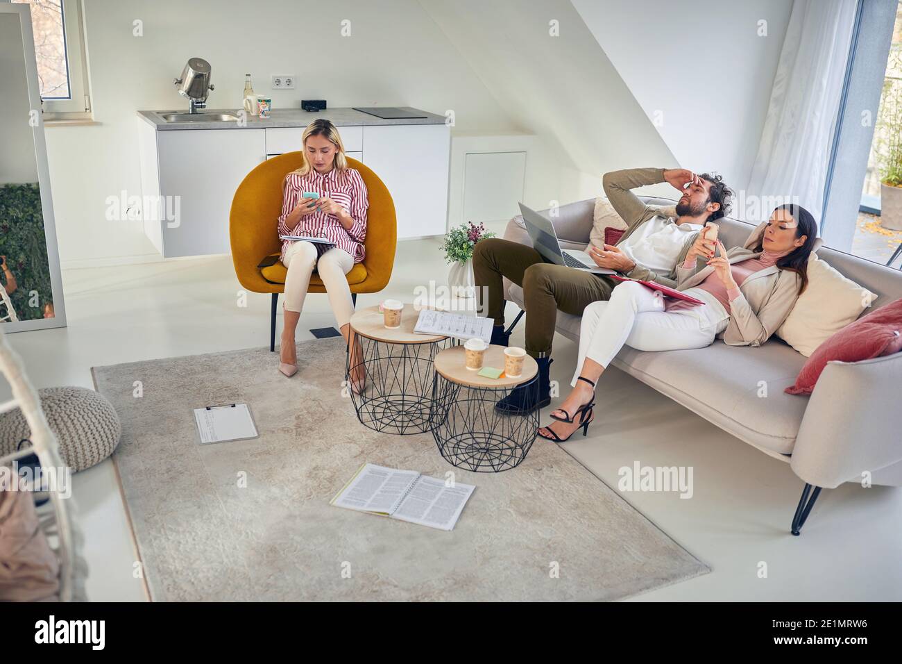 A group of young tired business people taking a break after hard work ...