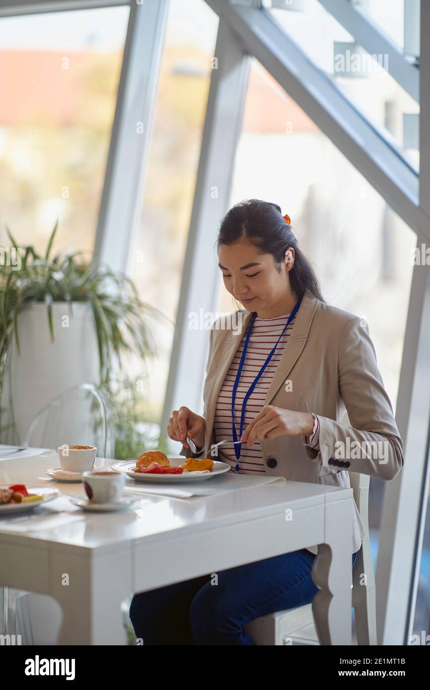Young female employee eating in a pleasant atmosphere at company ...