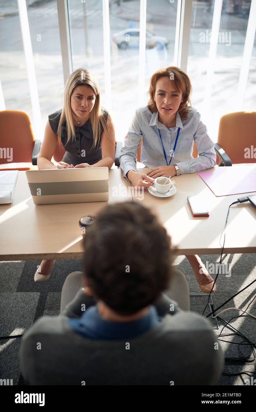 Man woman sitting across desk interview hi-res stock photography and ...