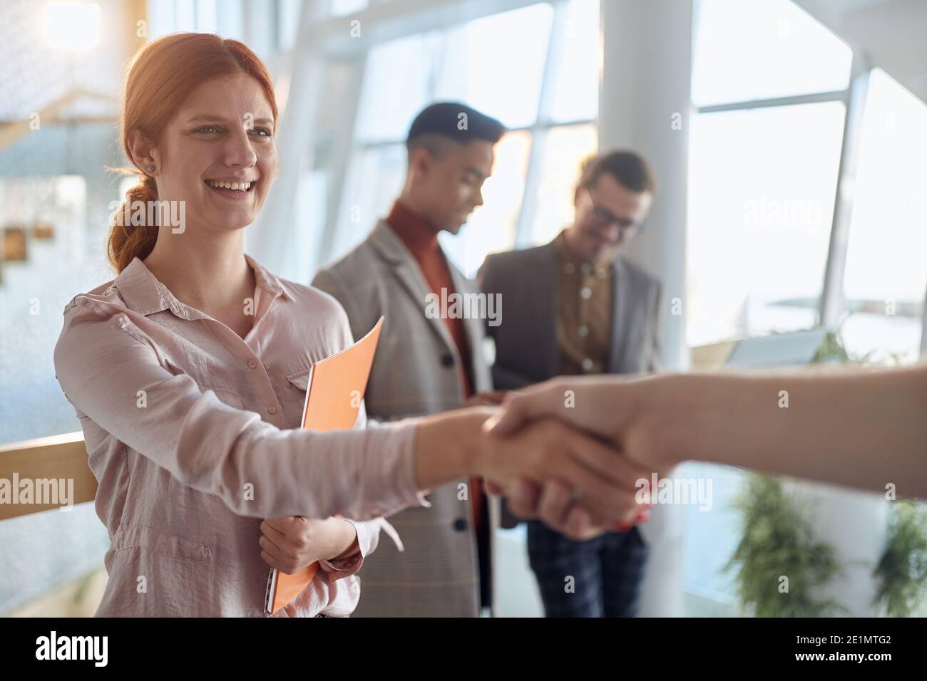 A young female employee has a business meeting at company in cheerful ...