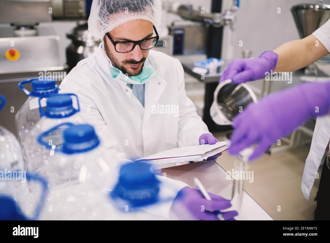 Cheerful lab employee taking notes of test experiments Stock Photo - Alamy