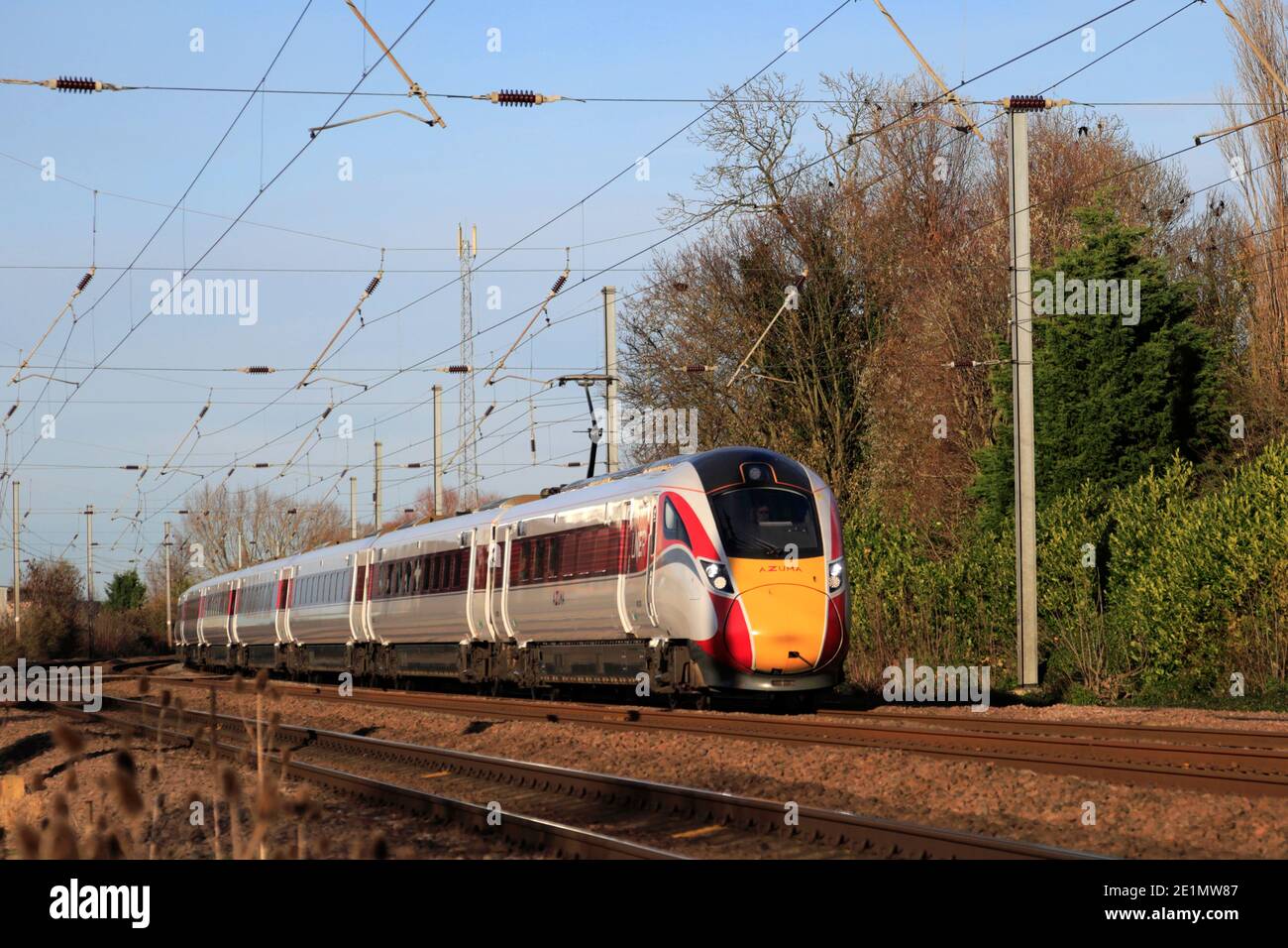 LNER, Azuma 800 class train passing Offord Cluny village, East Coast Main Line Railway ...