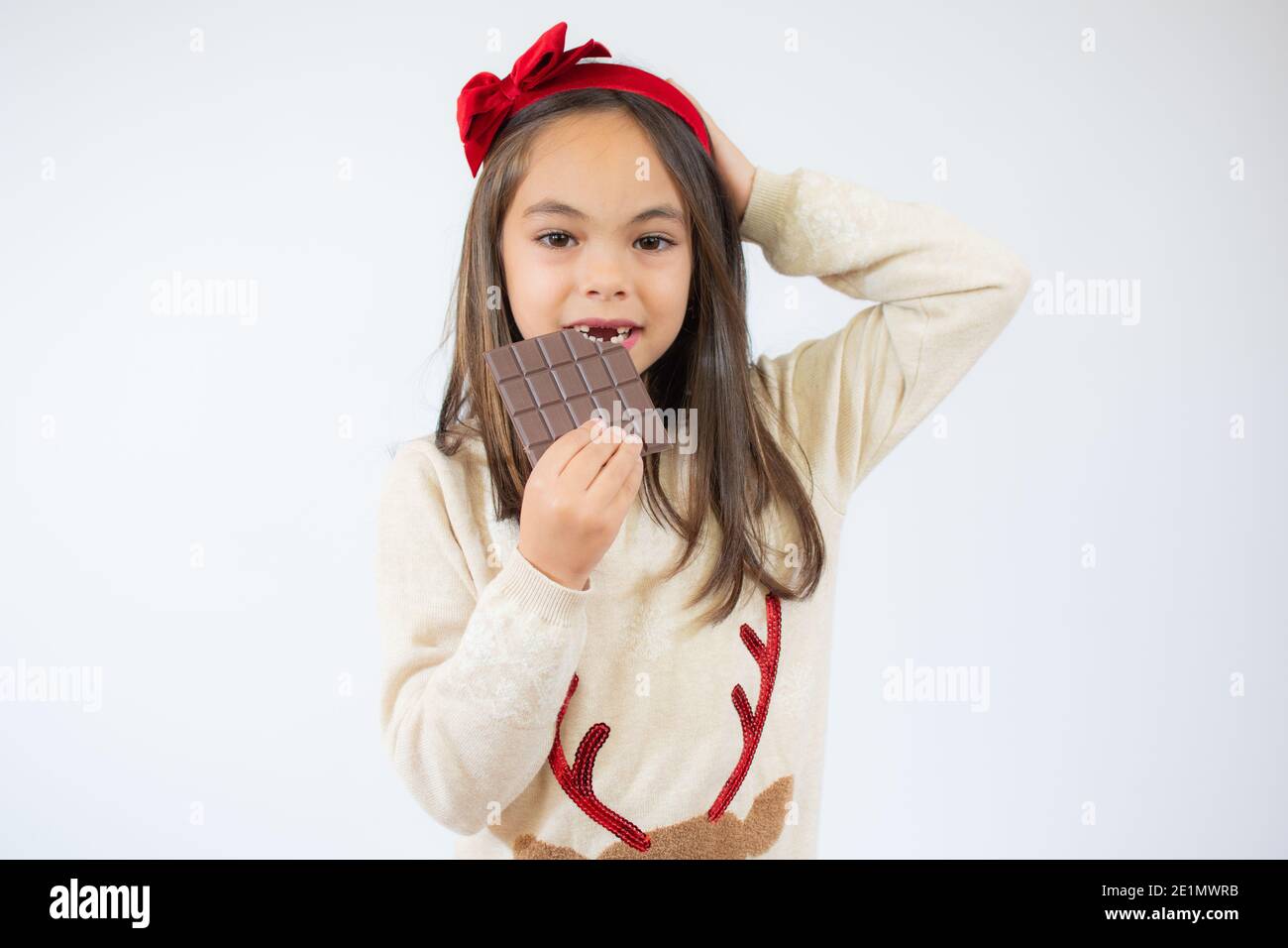 Beautiful little girl eating chocolate isolated over white background ...