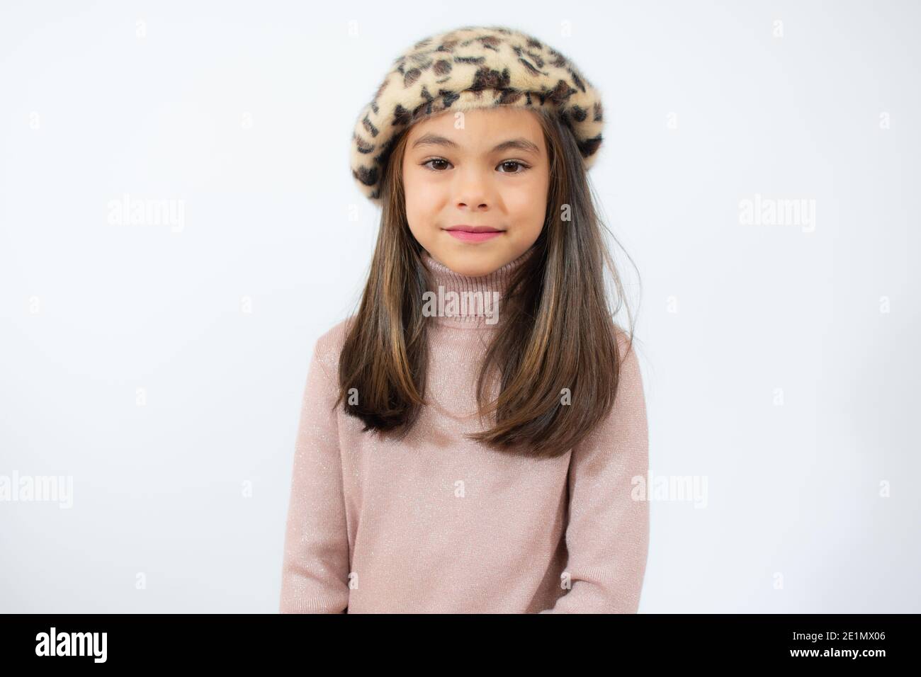 Close up portrait of pretty little girl wearing winter hat smiling over ...