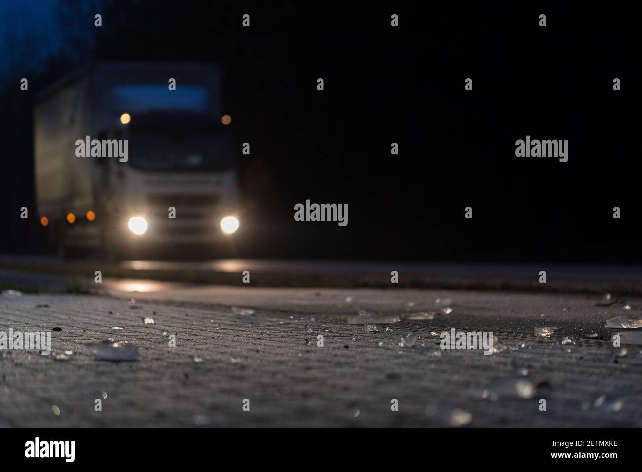 Ice smashed on a lantern lit sidewalk at night, blurred background with ...