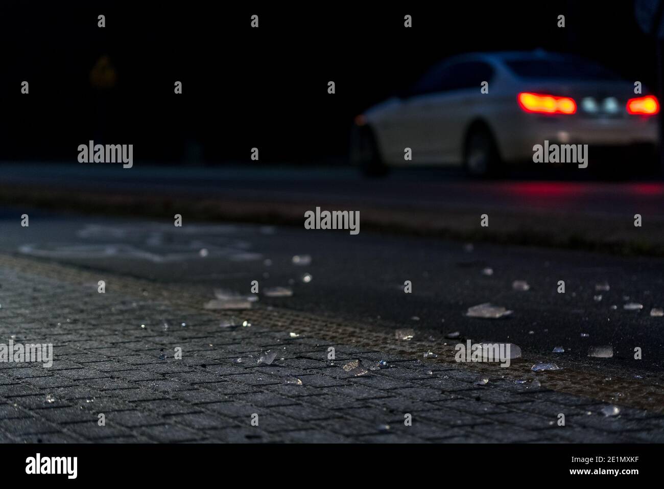 Ice smashed on a lantern lit sidewalk at night, blurred background with ...