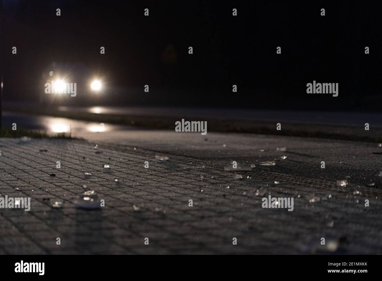 Ice smashed on a lantern lit sidewalk at night, blurred background with ...
