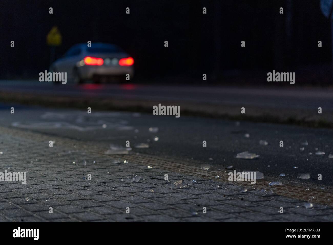 Ice smashed on a lantern lit sidewalk at night, blurred background with ...