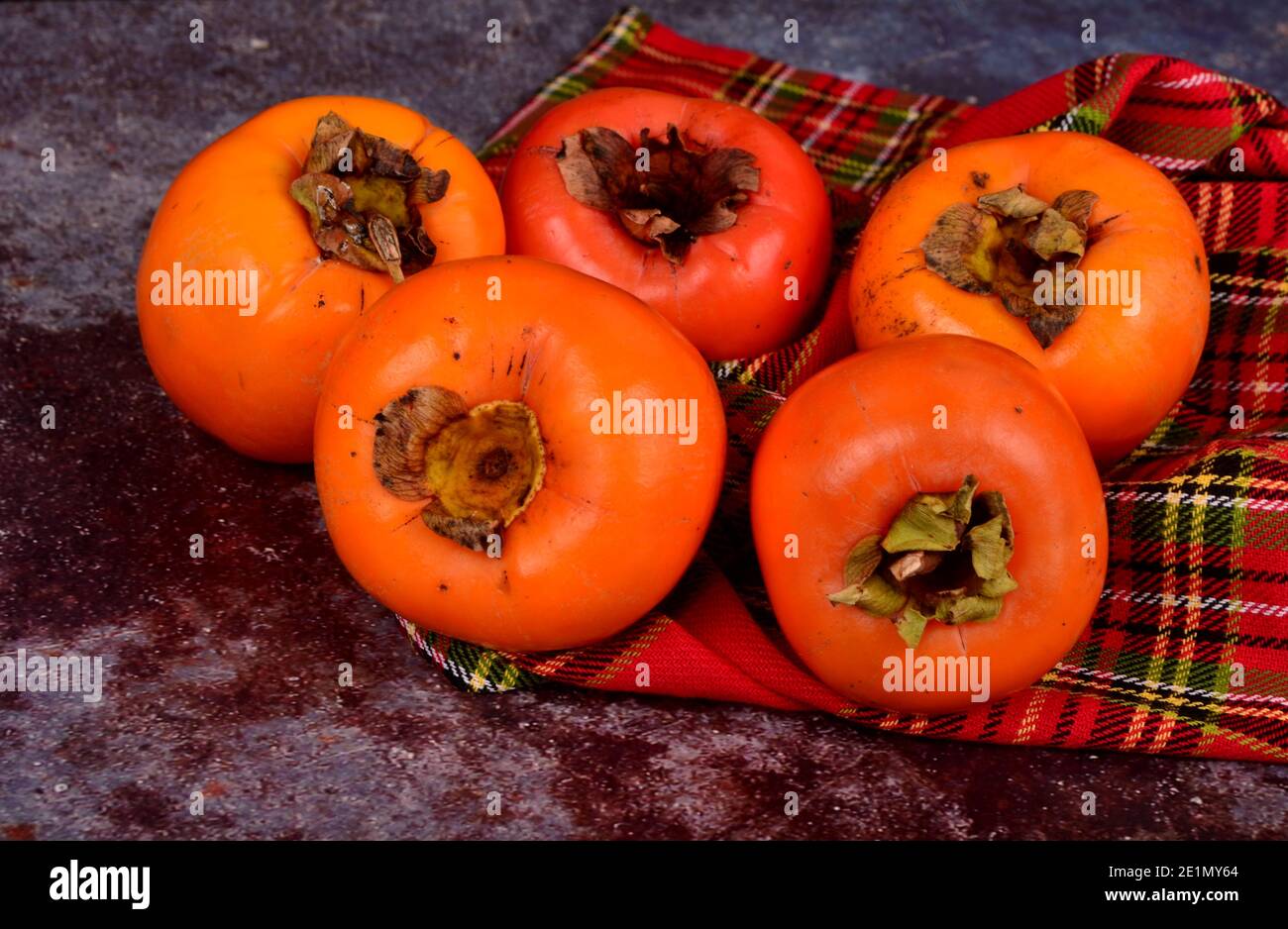 Group of Ripe orange persimmon fruit.Persimmon fruits in plate, rustic ...