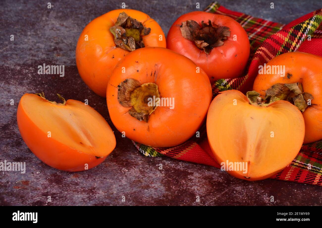 Group of Ripe orange persimmon fruit.Persimmon fruits in plate, rustic ...