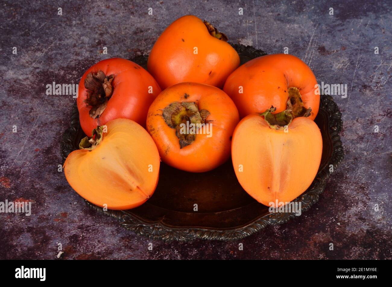 Group of Ripe orange persimmon fruit.Persimmon fruits in plate, rustic ...
