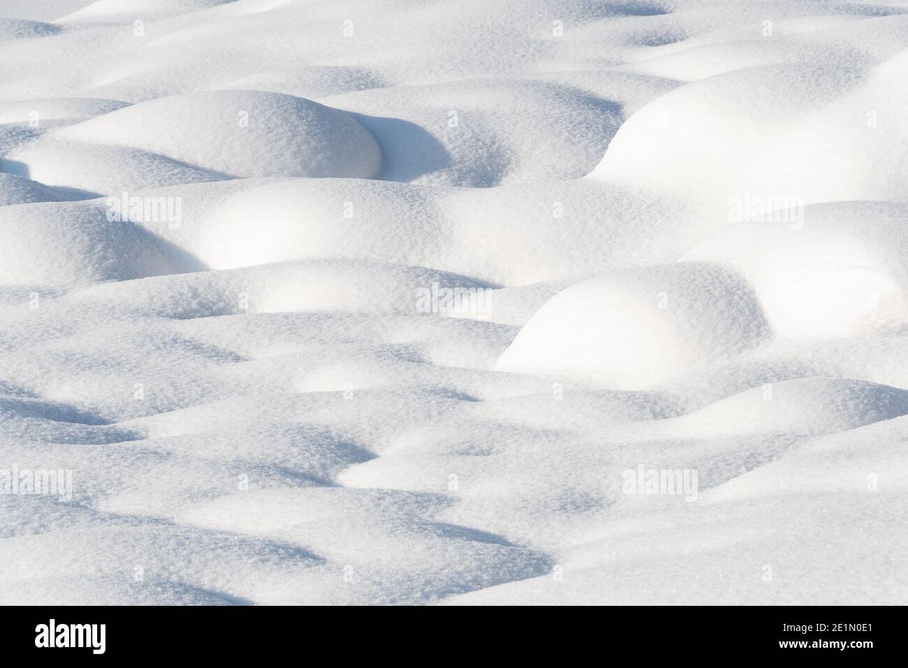 Smooth snow drifts on sunny winter day. Deep and high snow drifts ...