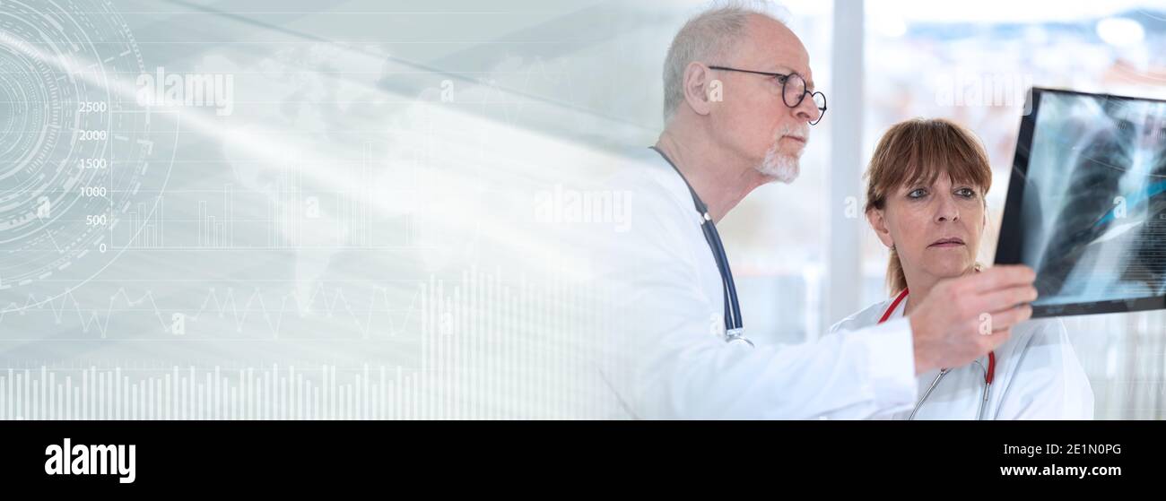 Two doctors examining x-ray report in medical office; panoramic banner ...