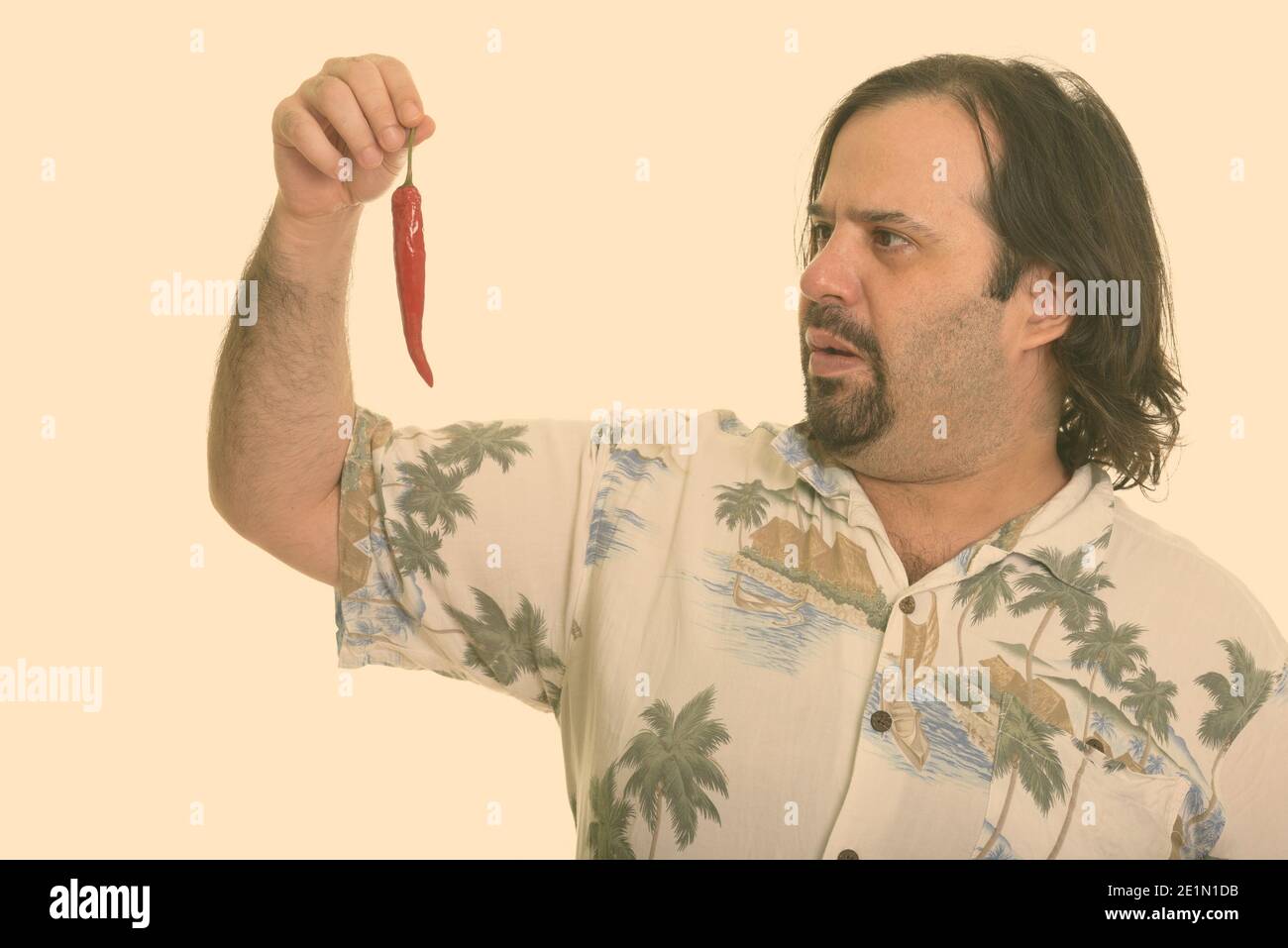 Fat Caucasian man looking at spicy chili pepper Stock Photo - Alamy