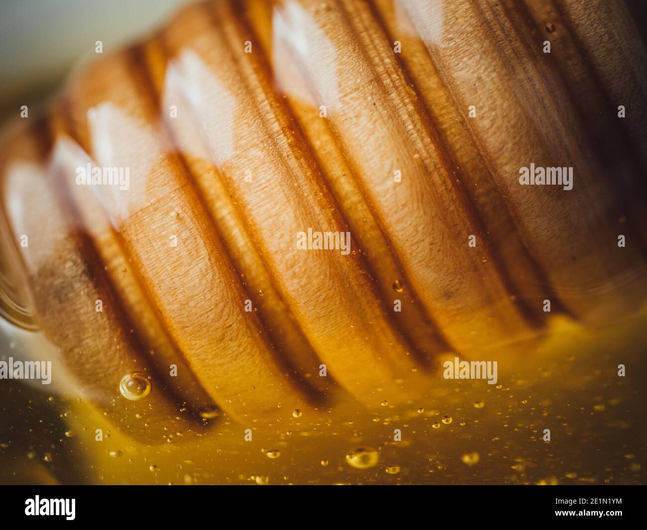 Close up of golden honey. Flow of honey. honey dipper is inside Yellow ...
