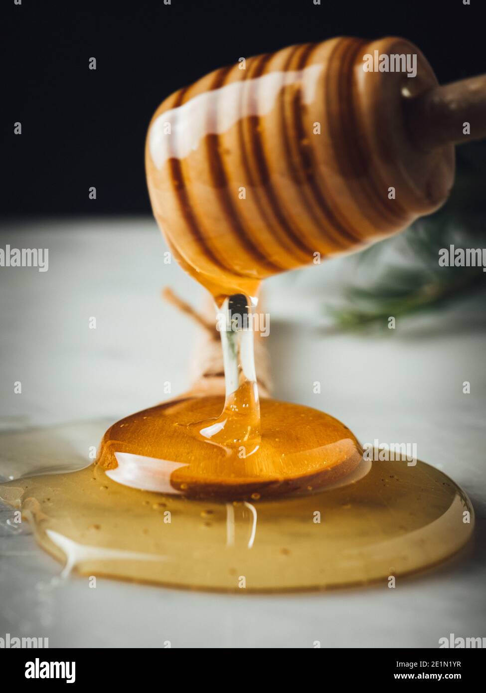 Flow of honey. Golden, yellow, raw honey is dropping from honey dipper ...
