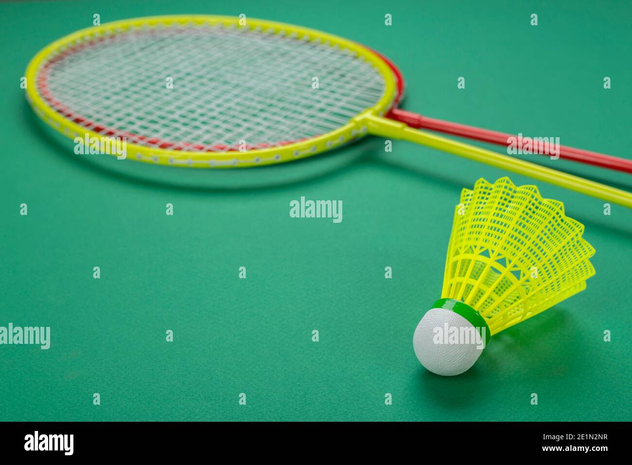 Shuttlecock and racket for playing badminton on a green background ...