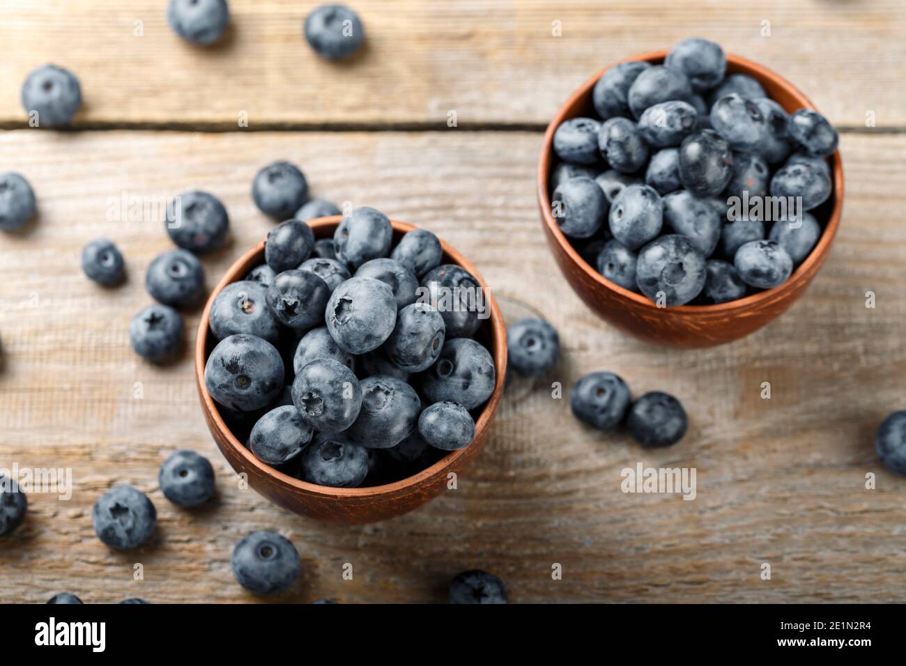 Freshly picked blueberries in clay bowl on wooden background. Concept ...