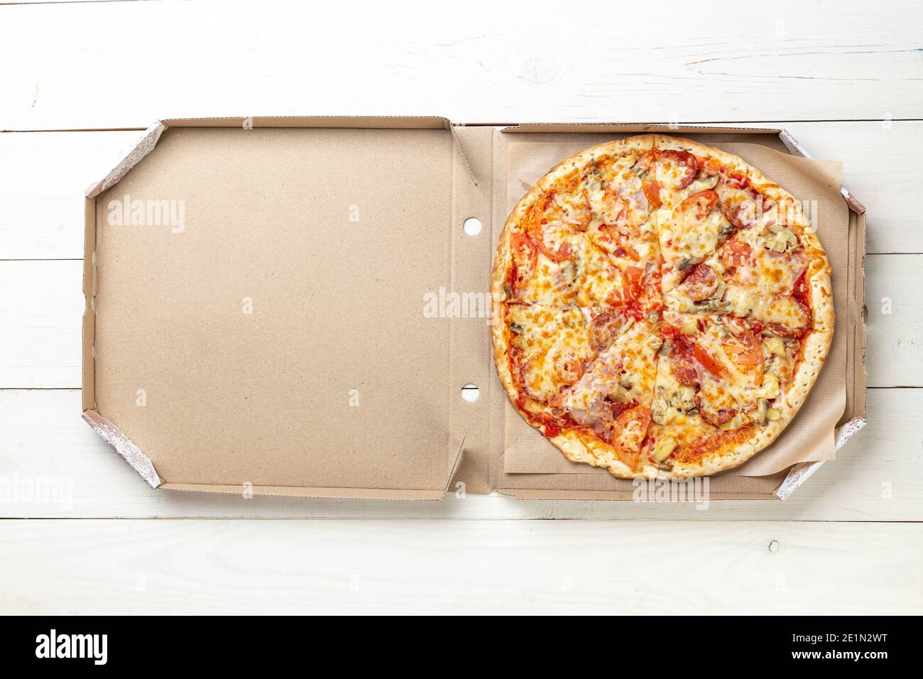 Pizza in a cardboard box against a white background. Space for text ...