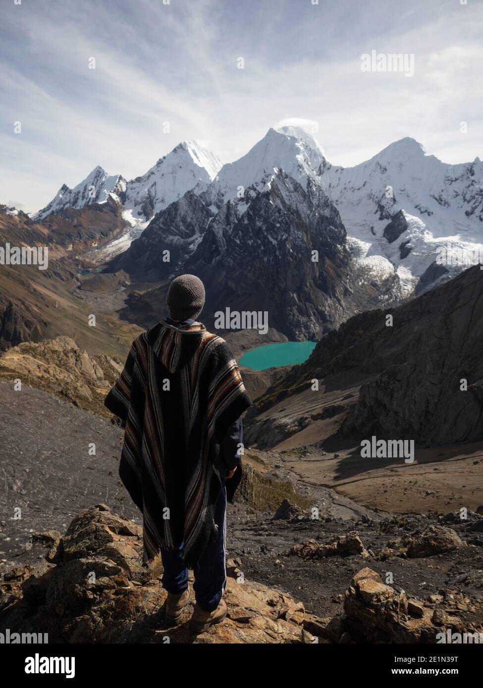 Young male hiker in traditional peruvian poncho at Cordillera Huayhuash ...