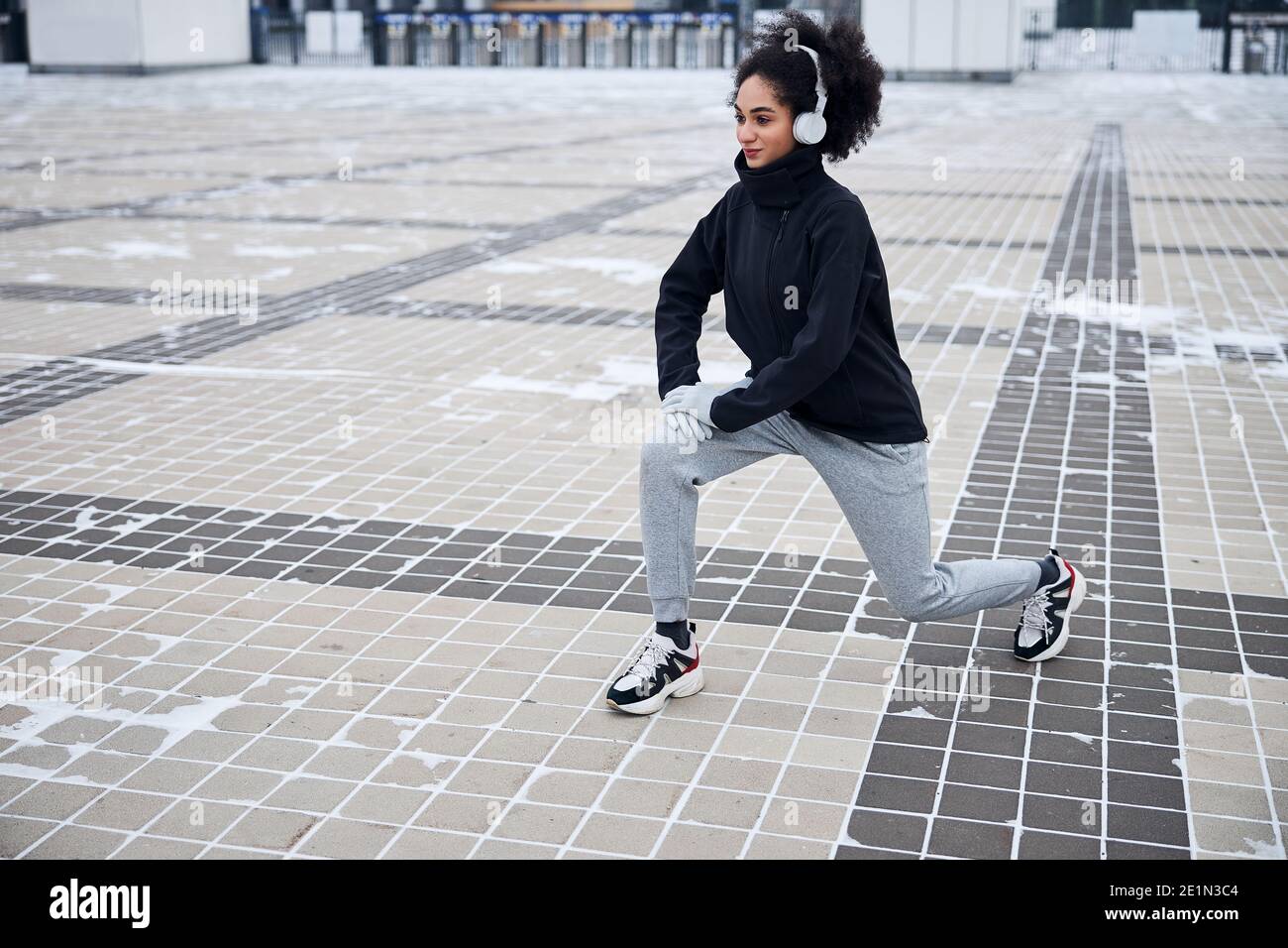 Sportswoman on a square doing the leg stretch Stock Photo - Alamy