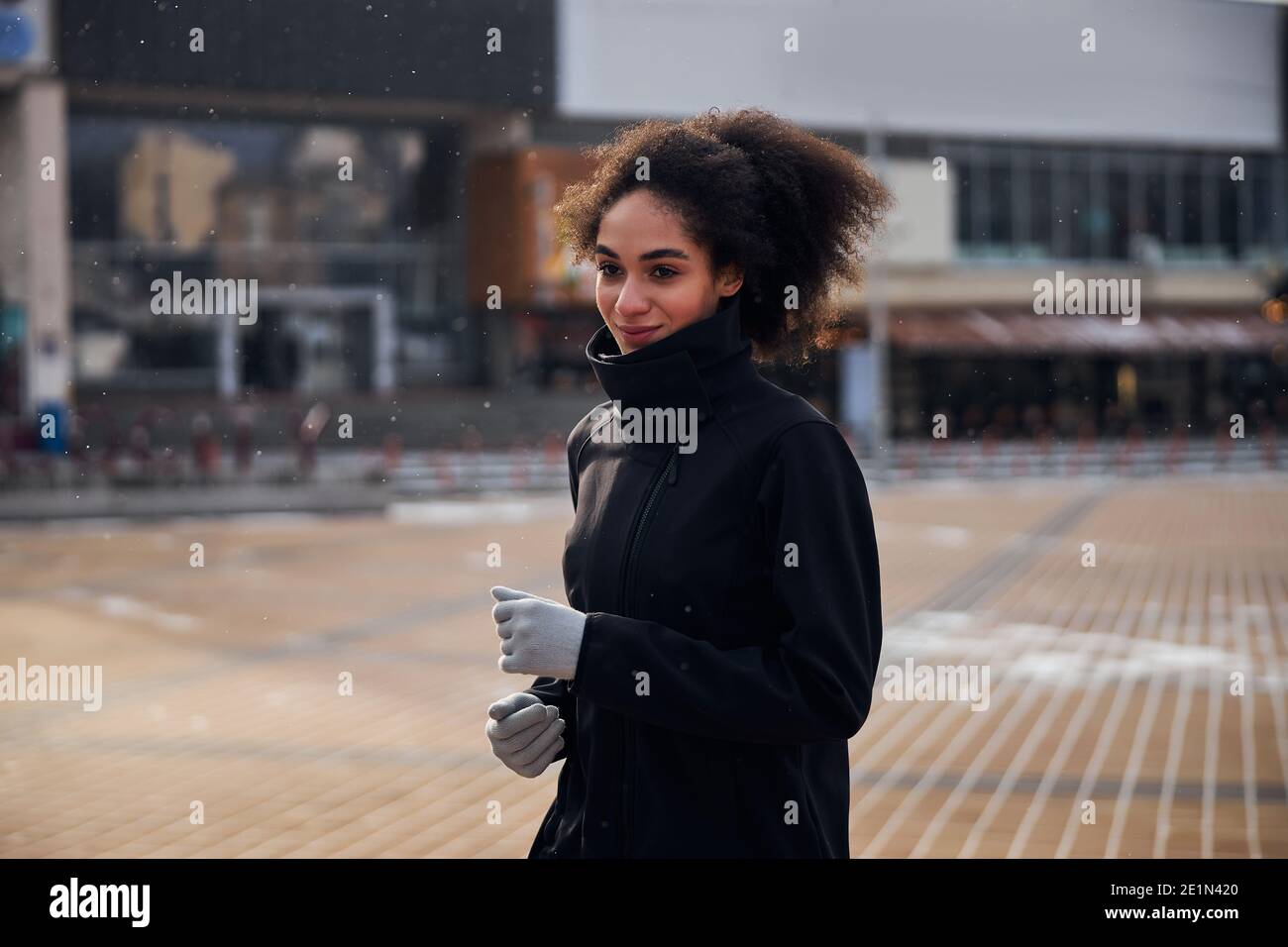 Athletic female jogging through an empty square Stock Photo - Alamy