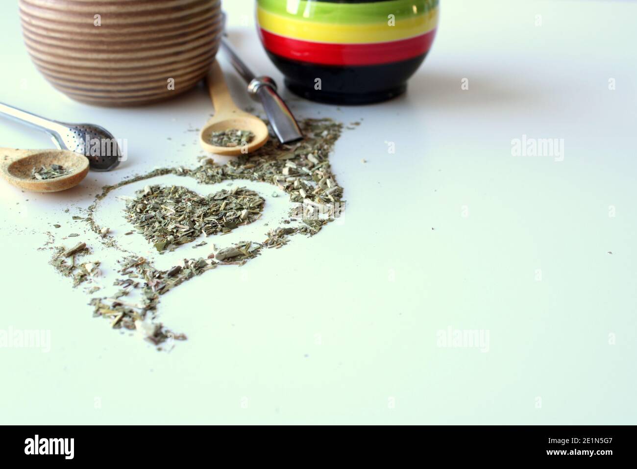 Composition on white background - bombilla, calabash, spoon and leaves ...