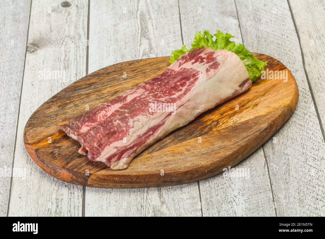 Raw beef bacon over wooden board served salad and thyme Stock Photo - Alamy