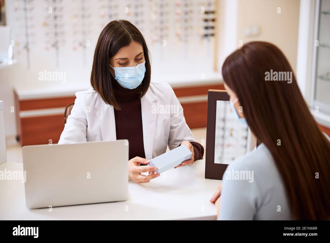 Focused doctor reading the instructions on a lenses package Stock Photo ...
