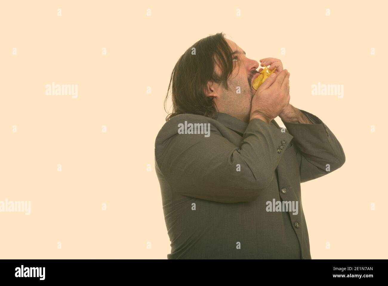 Fat Caucasian businessman eating mouthful of chips Stock Photo - Alamy