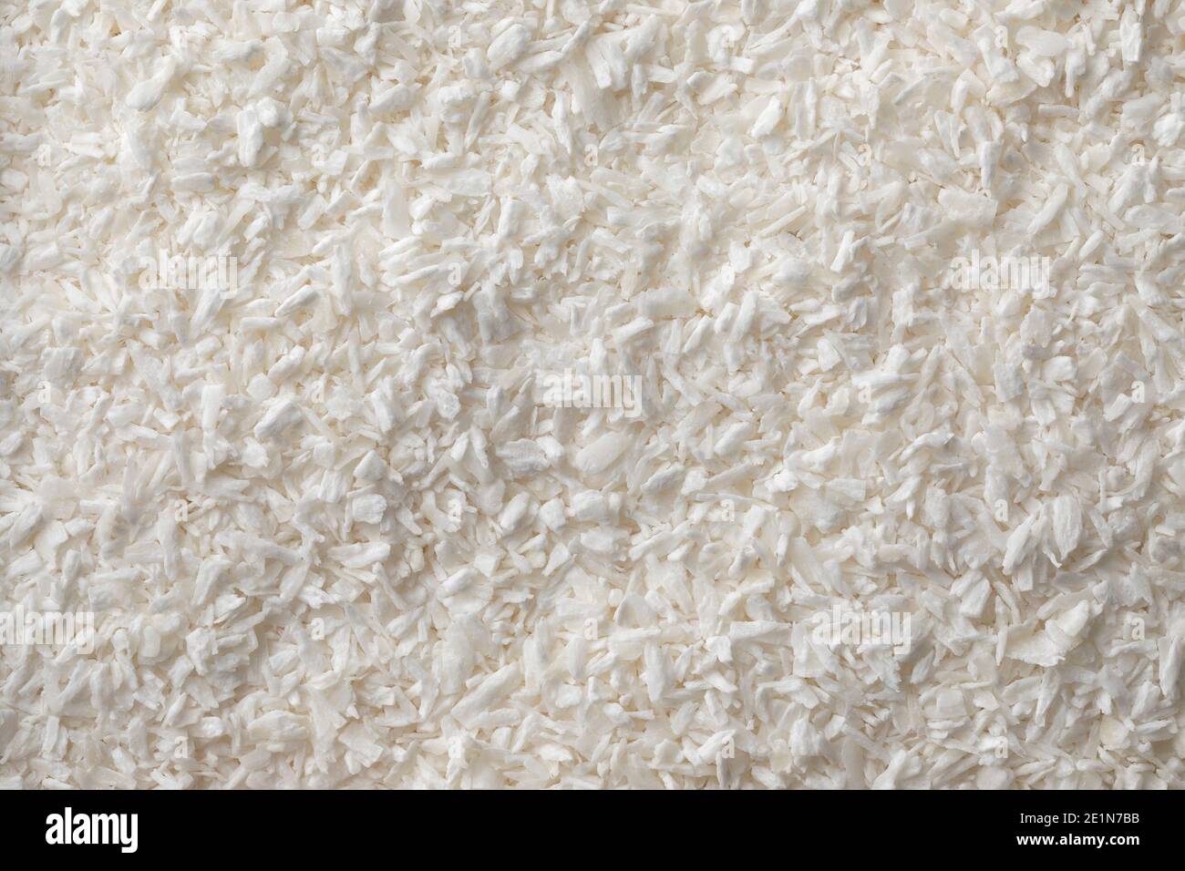 White dried shredded coconut meat full frame close up as a background ...