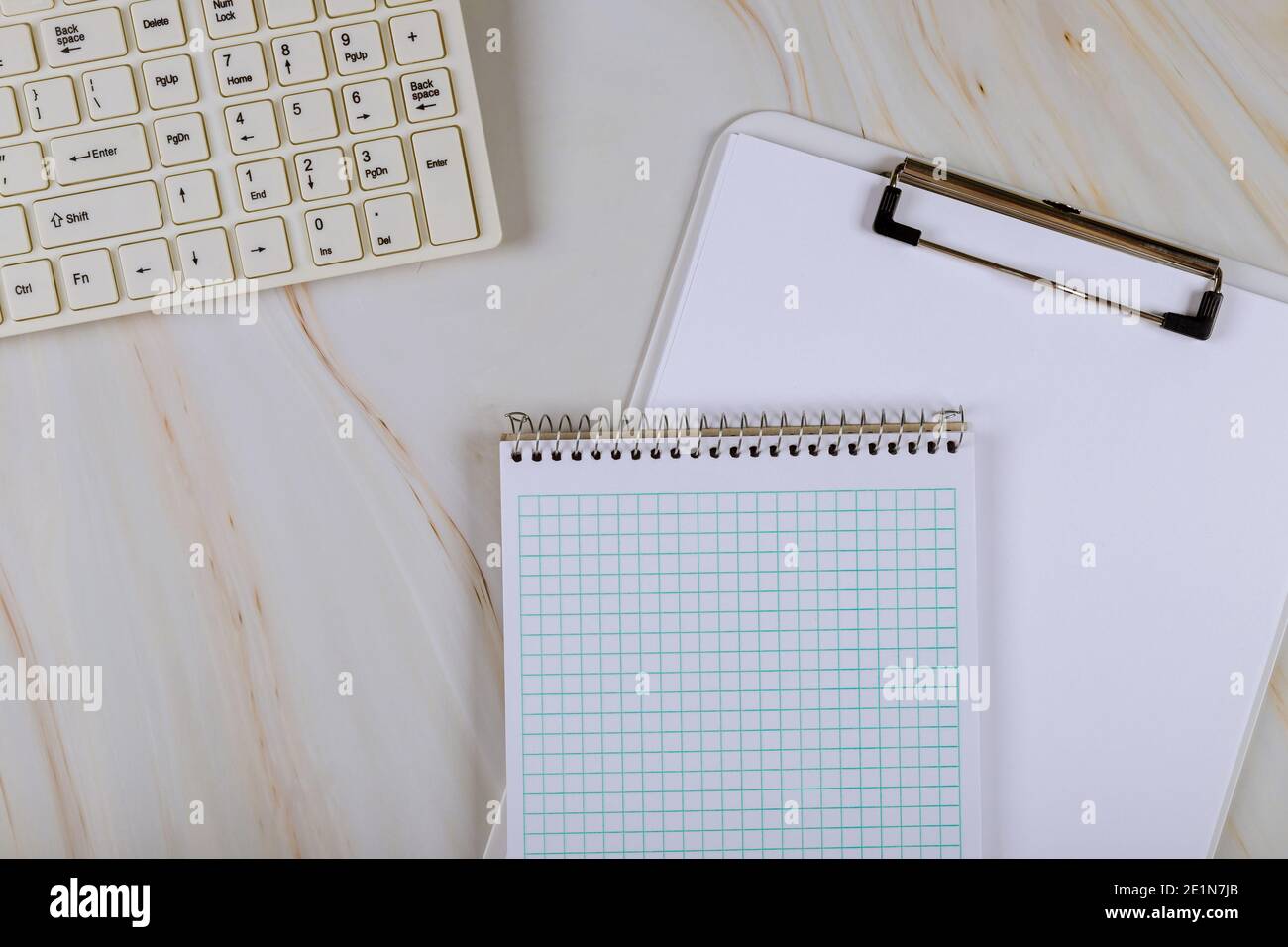 Workplace with office supplies on computer keyboard open blank notebook ...