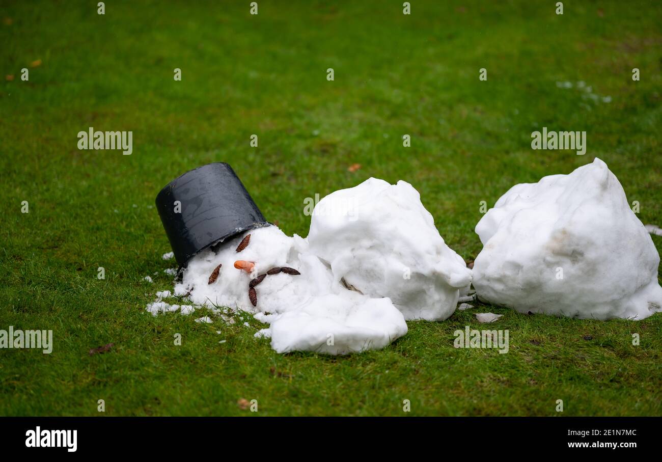 A melted snow man with a sad face as symbol of the end of the winter ...