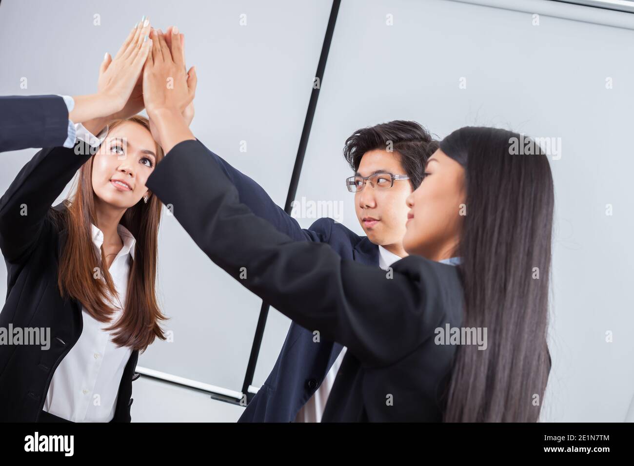 Young business of Asian people standing and join hand together with ...