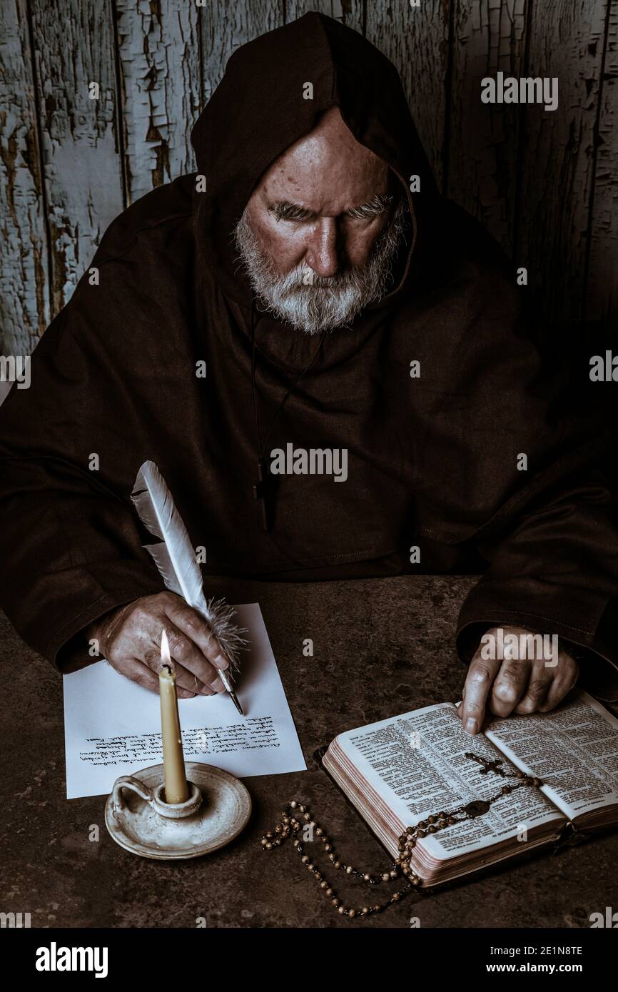 Franciscan monk writing in his cell, with his bible to hand Stock Photo ...