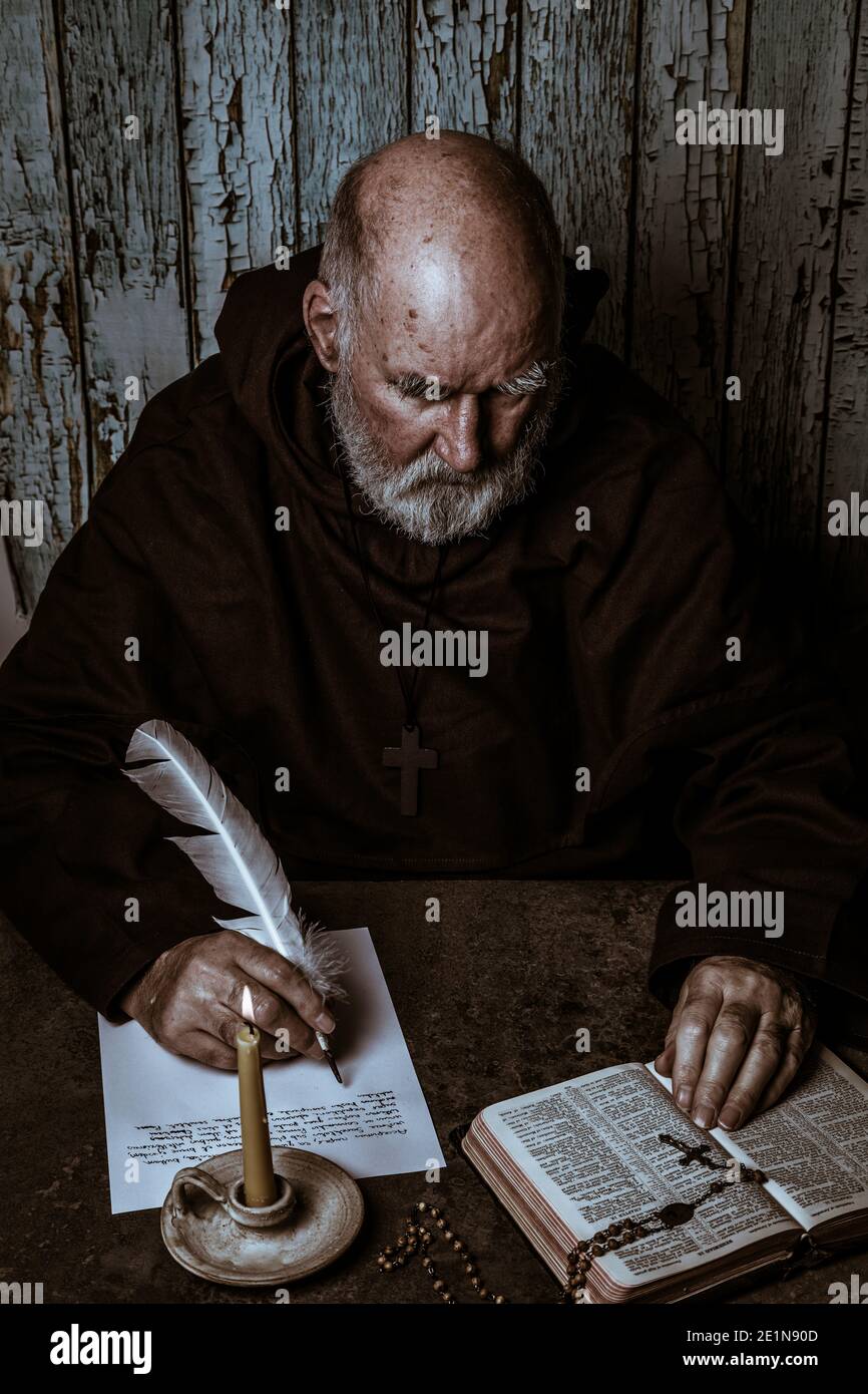 Franciscan monk writing in his cell, with his bible to hand Stock Photo ...