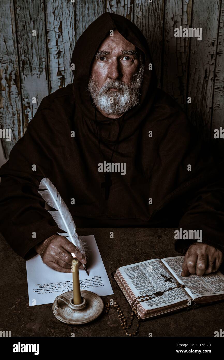 Franciscan monk writing in his cell, with his bible to hand Stock Photo ...