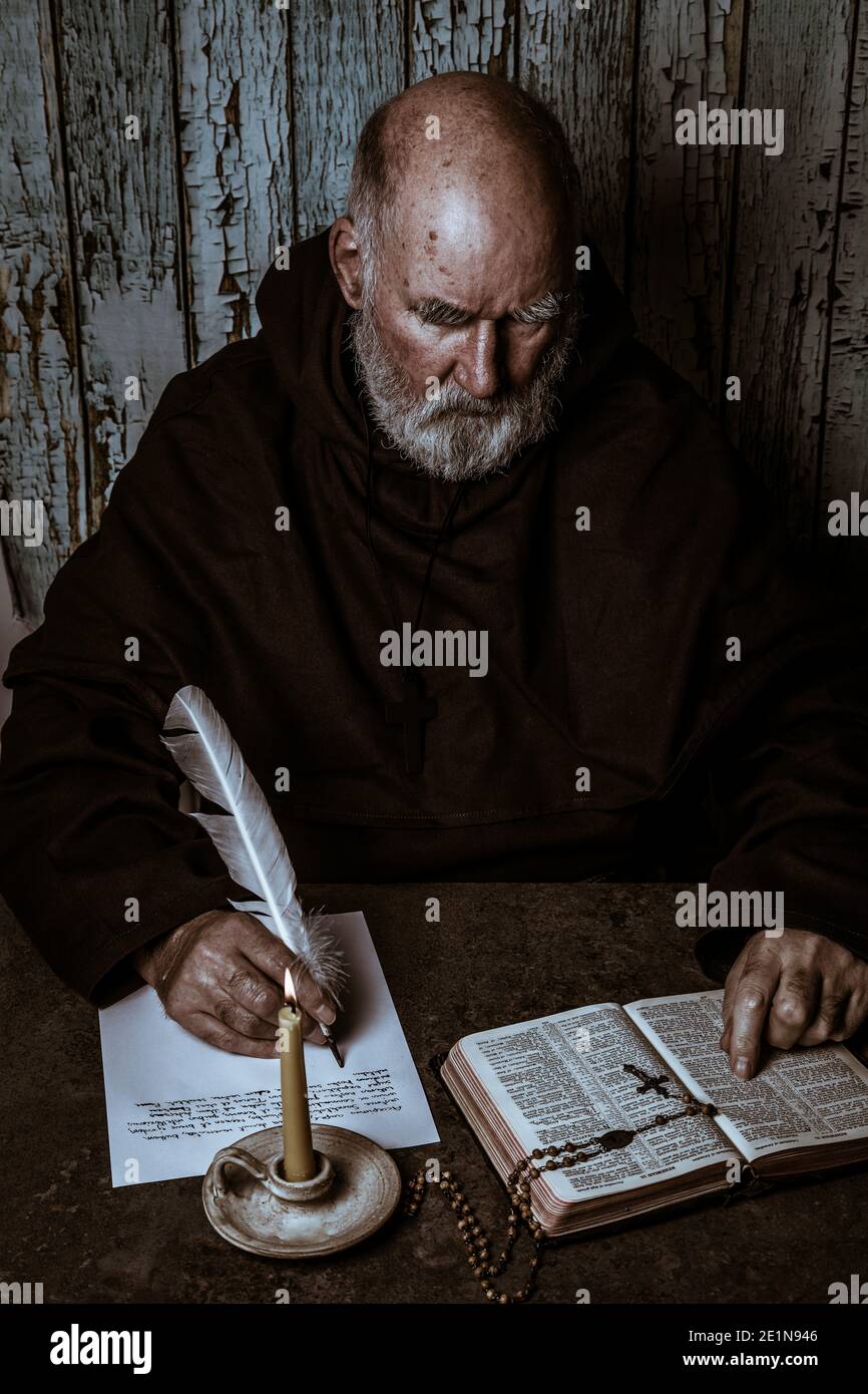 Franciscan monk writing in his cell, with his bible to hand Stock Photo ...