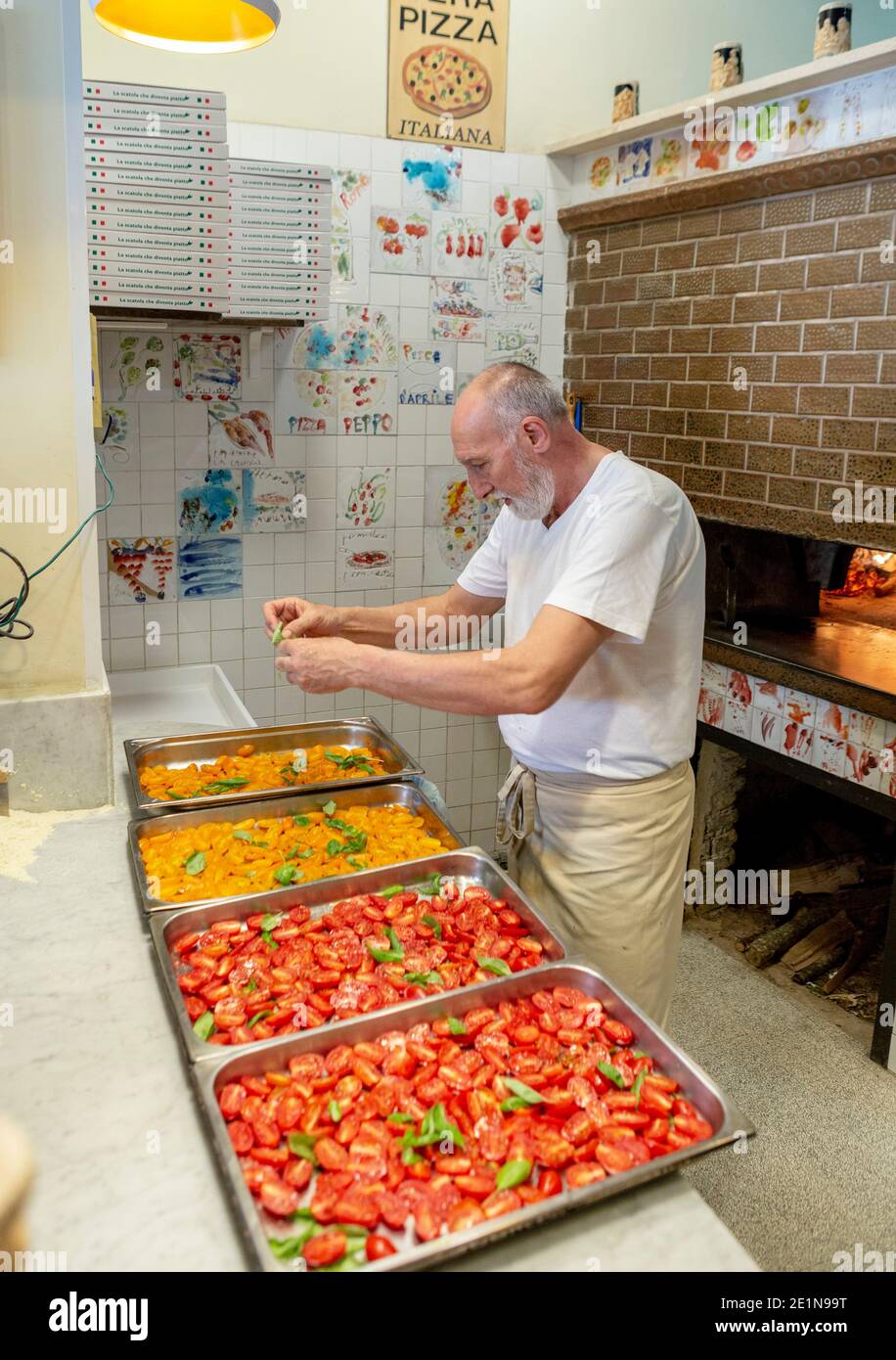Pizzaiolo pizza chef prepares tomatoes for the pizza Stock Photo - Alamy