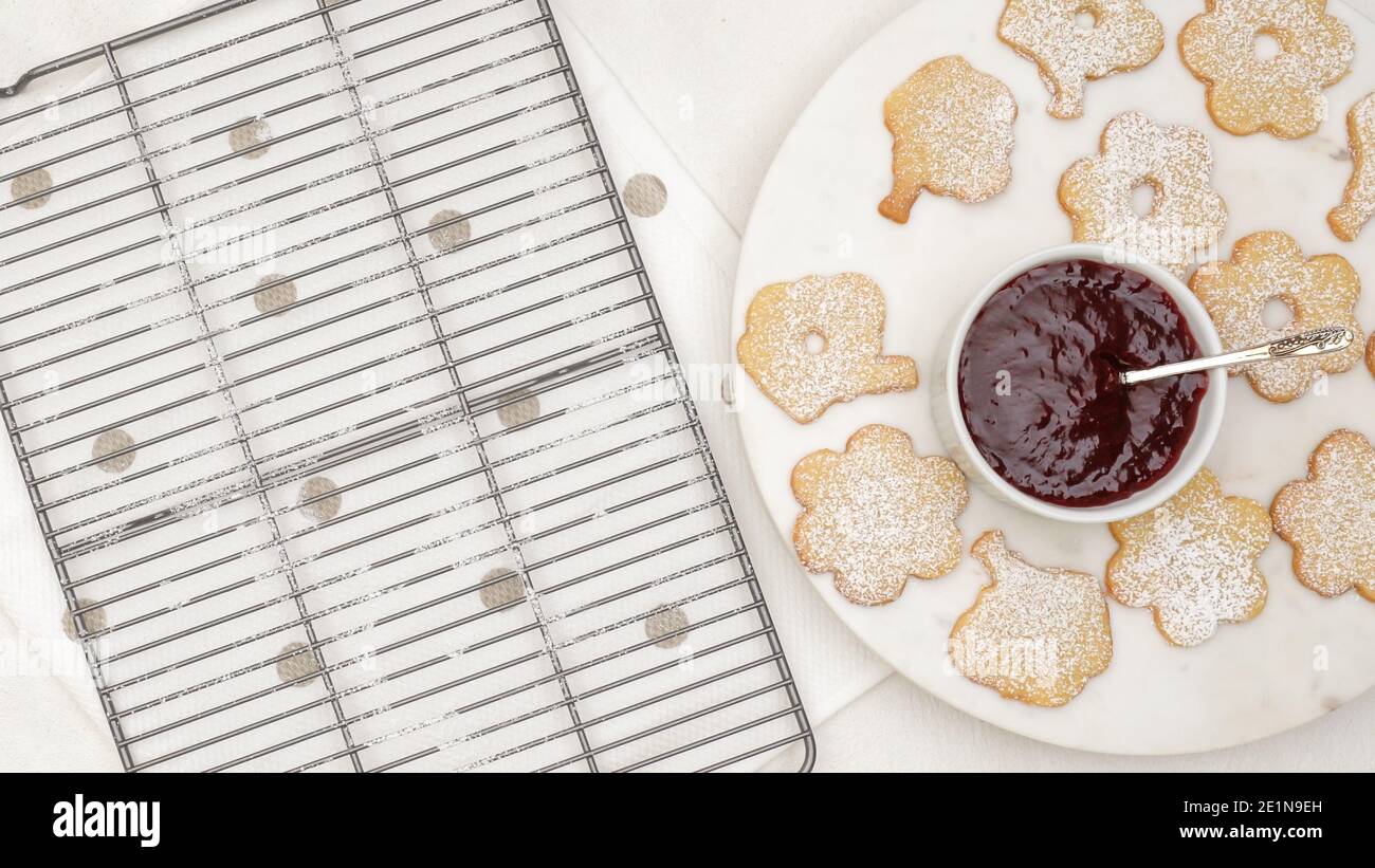 Flower shaped shortbread cookies filled with raspberry jam recipe Stock ...