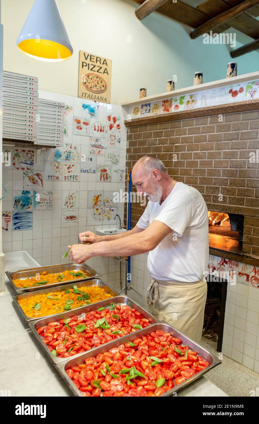 Pizzaiolo pizza chef prepares tomatoes for the pizza Stock Photo - Alamy