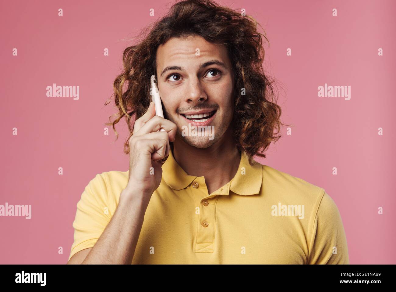 Happy handsome guy smiling while talking on mobile phone isolated over ...