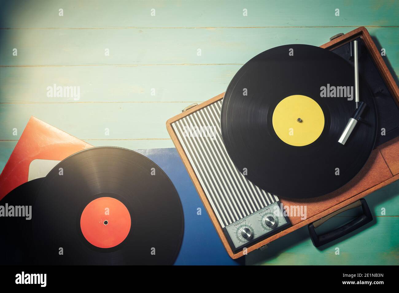 Vintage gramophone from the 70s with a vinyl records on green wooden ...