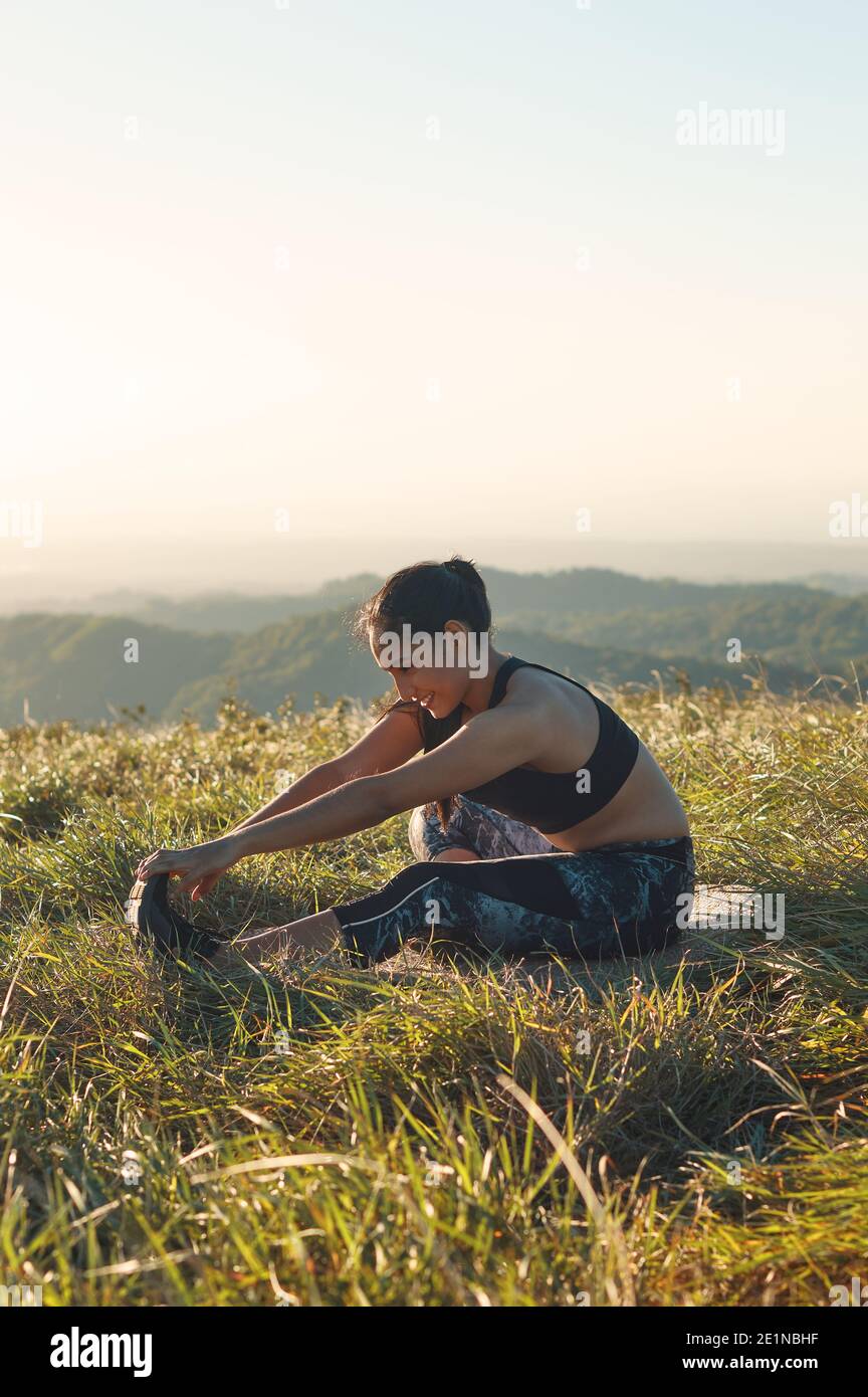 An image of woman wearing sporty clothes and stretching her body ...