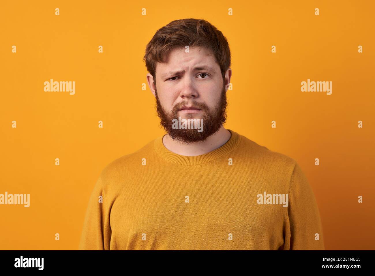 Bewildered man with thick ginger beard, raises eyebrows, reacts on fake ...